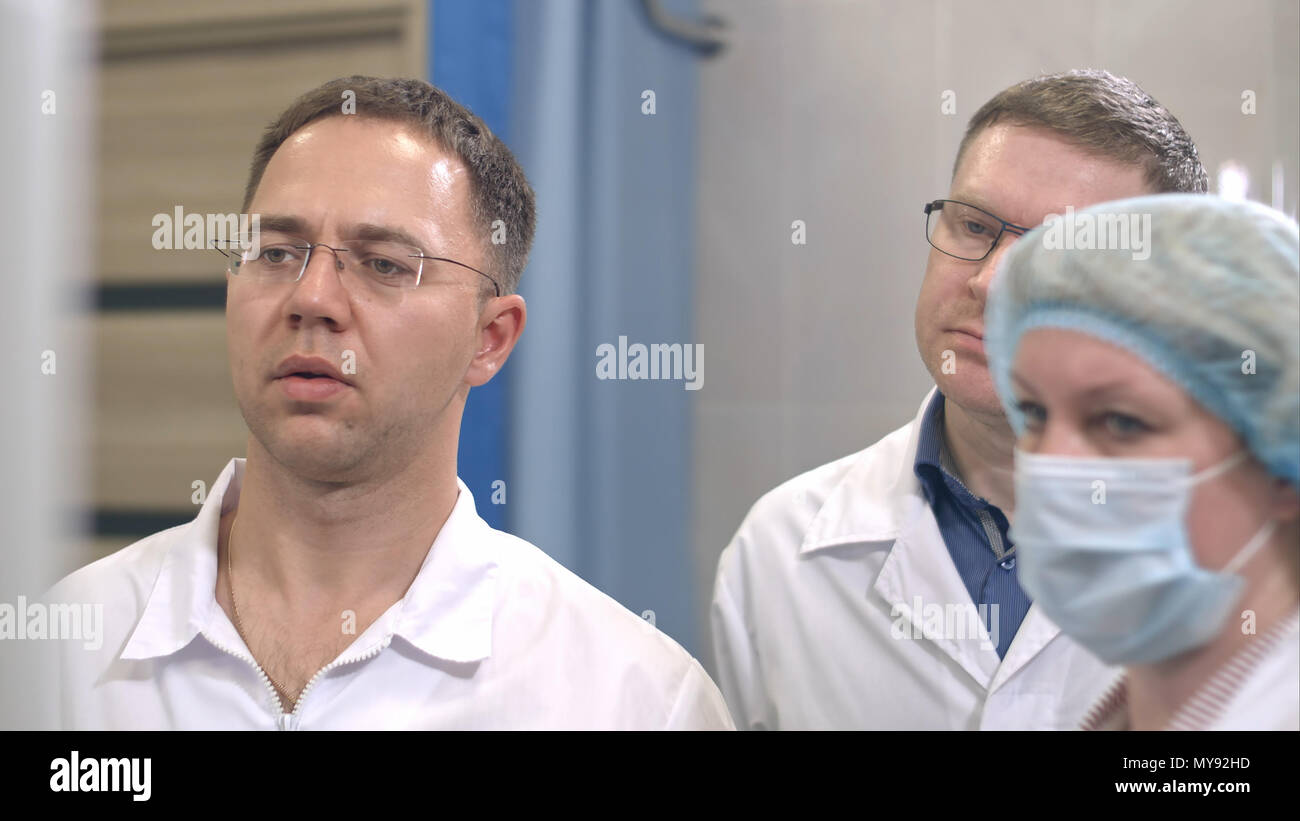 Two male doctors and a nurse managing surgery Stock Photo - Alamy
