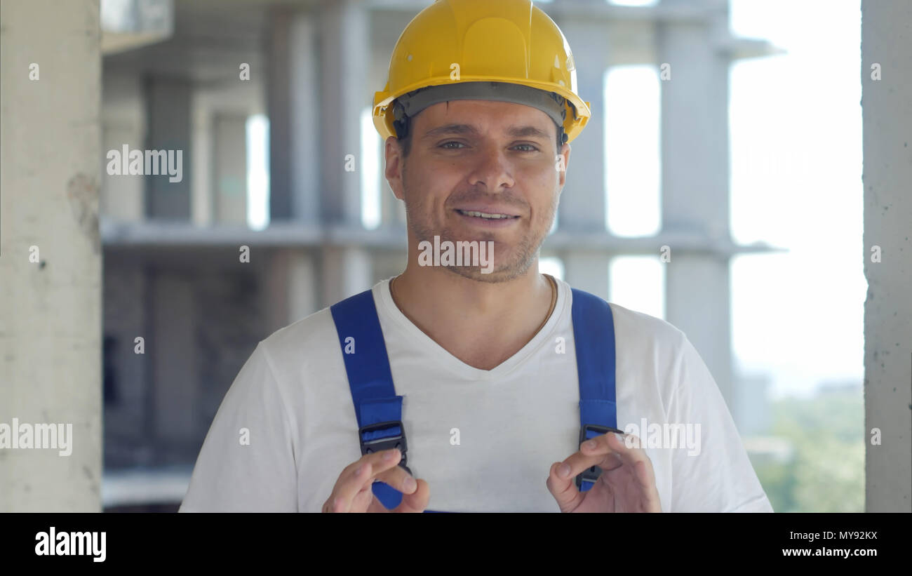 Construction worker talks to camera in front of building site Stock ...