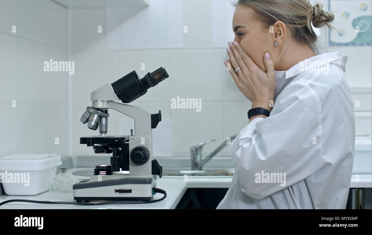 Surprised woman working with a microscope in laboratory Stock Photo - Alamy