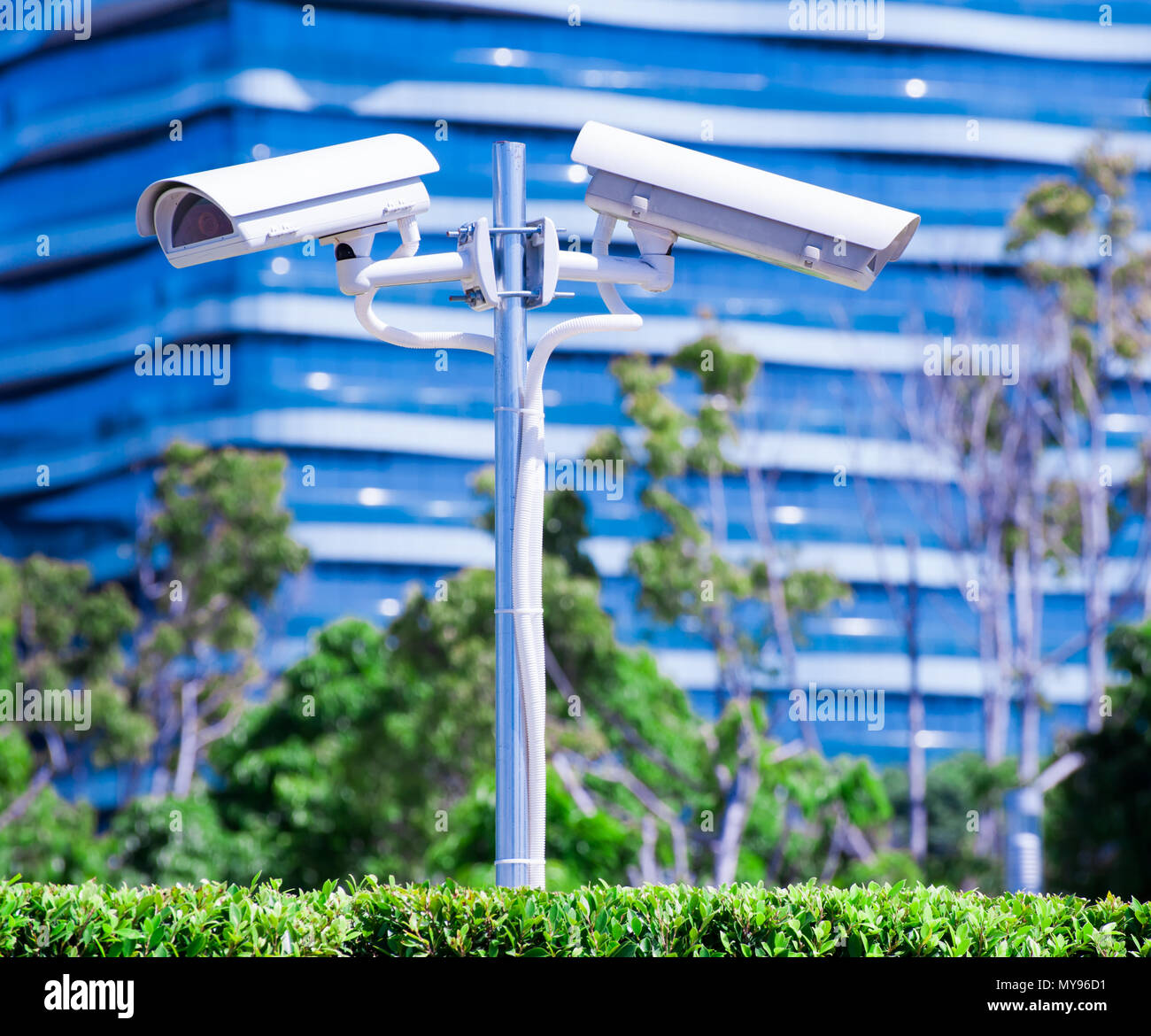 CCTV camera or surveillance operaiting with blue building and park in ...