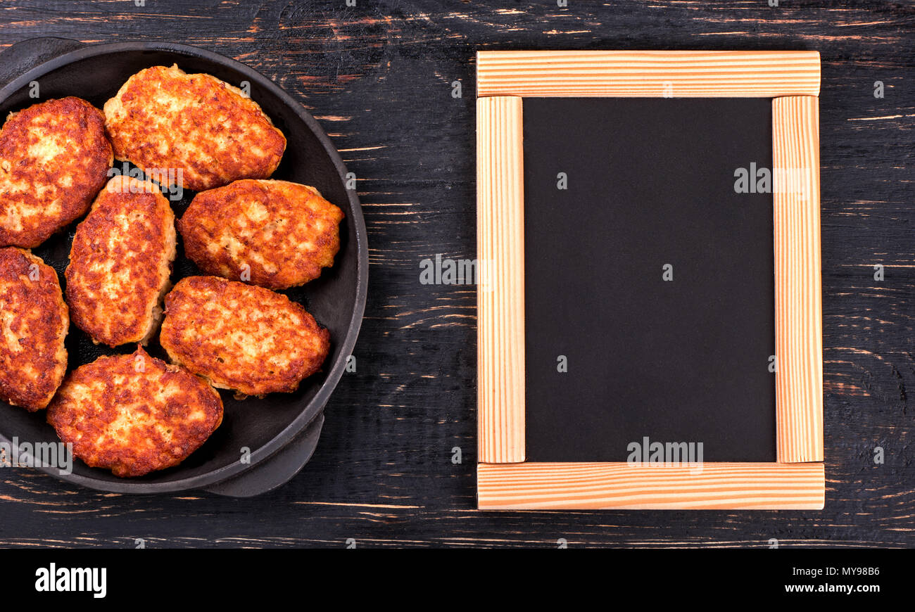 Fried cutlets in a pan with an empty table for menus and recipes, top ...