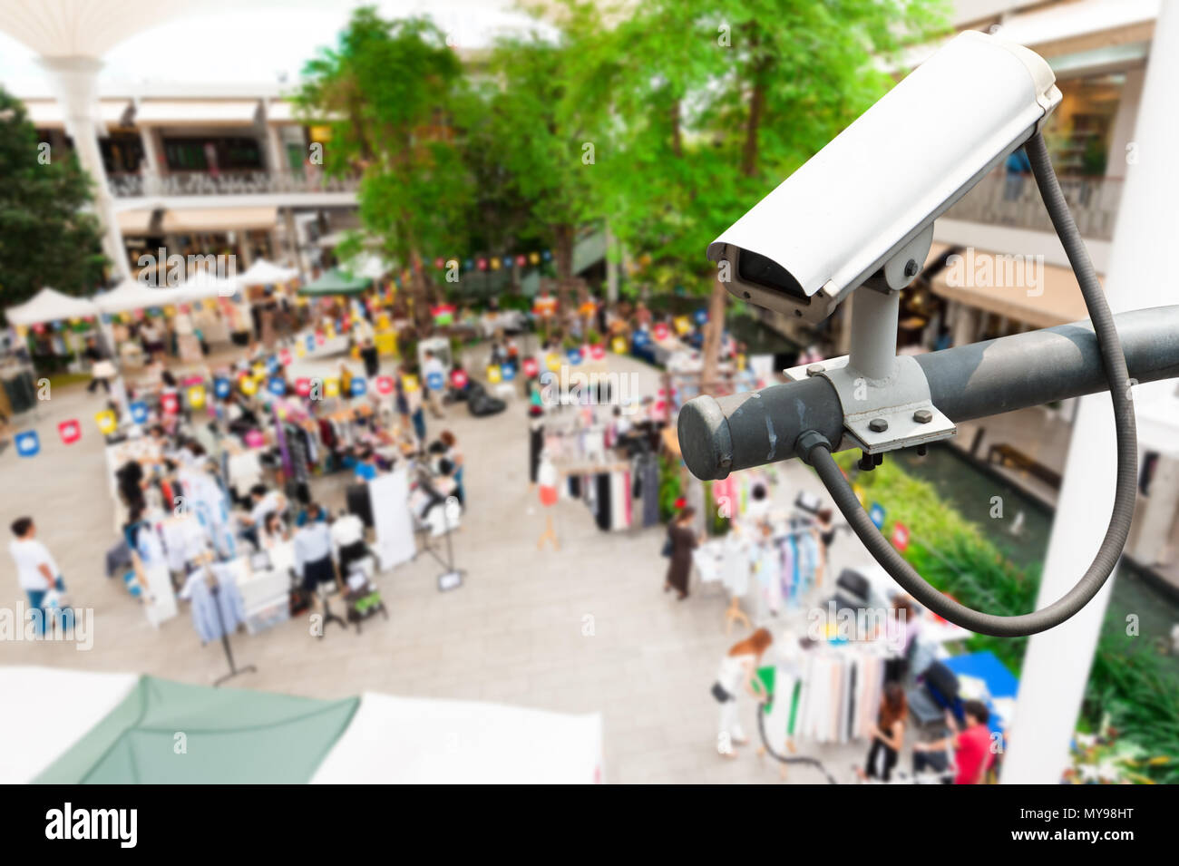 CCTV camera or surveillance operating with crowded people in background ...