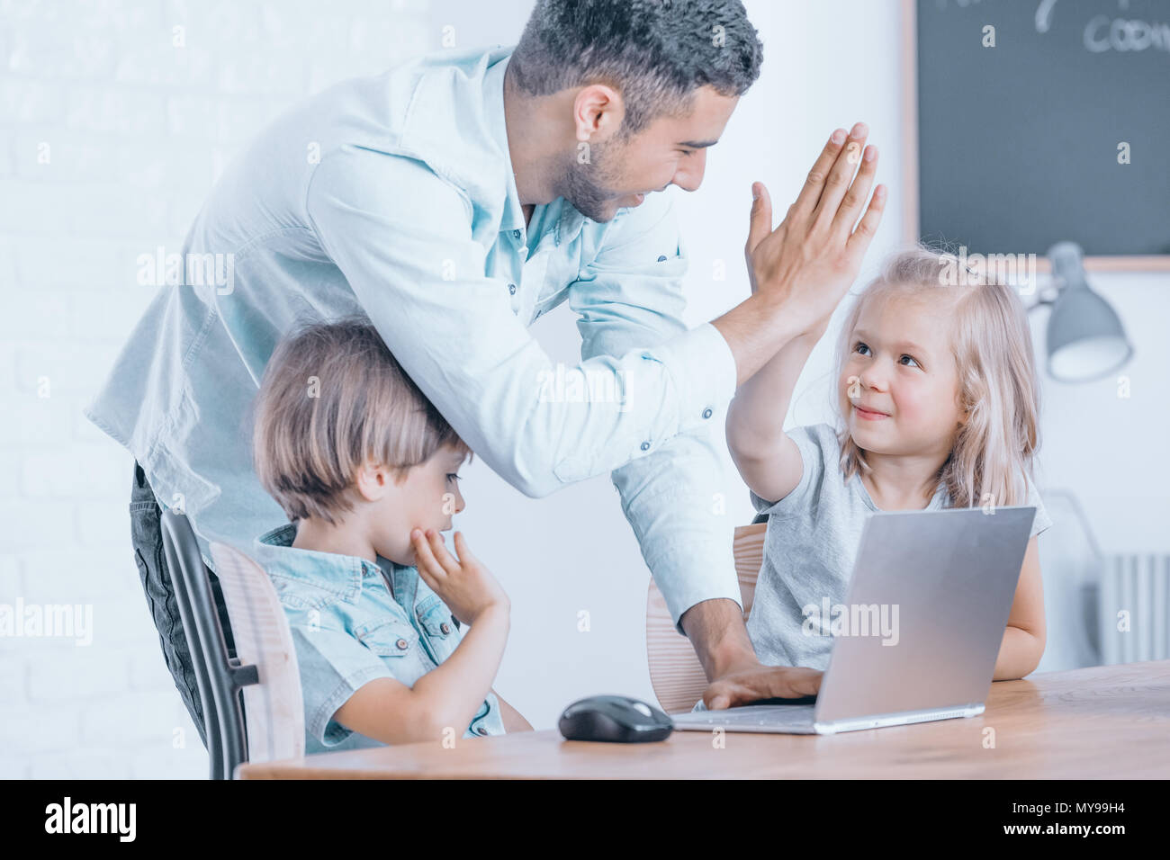 Happy teacher congratulates girl in the task of programming during ...