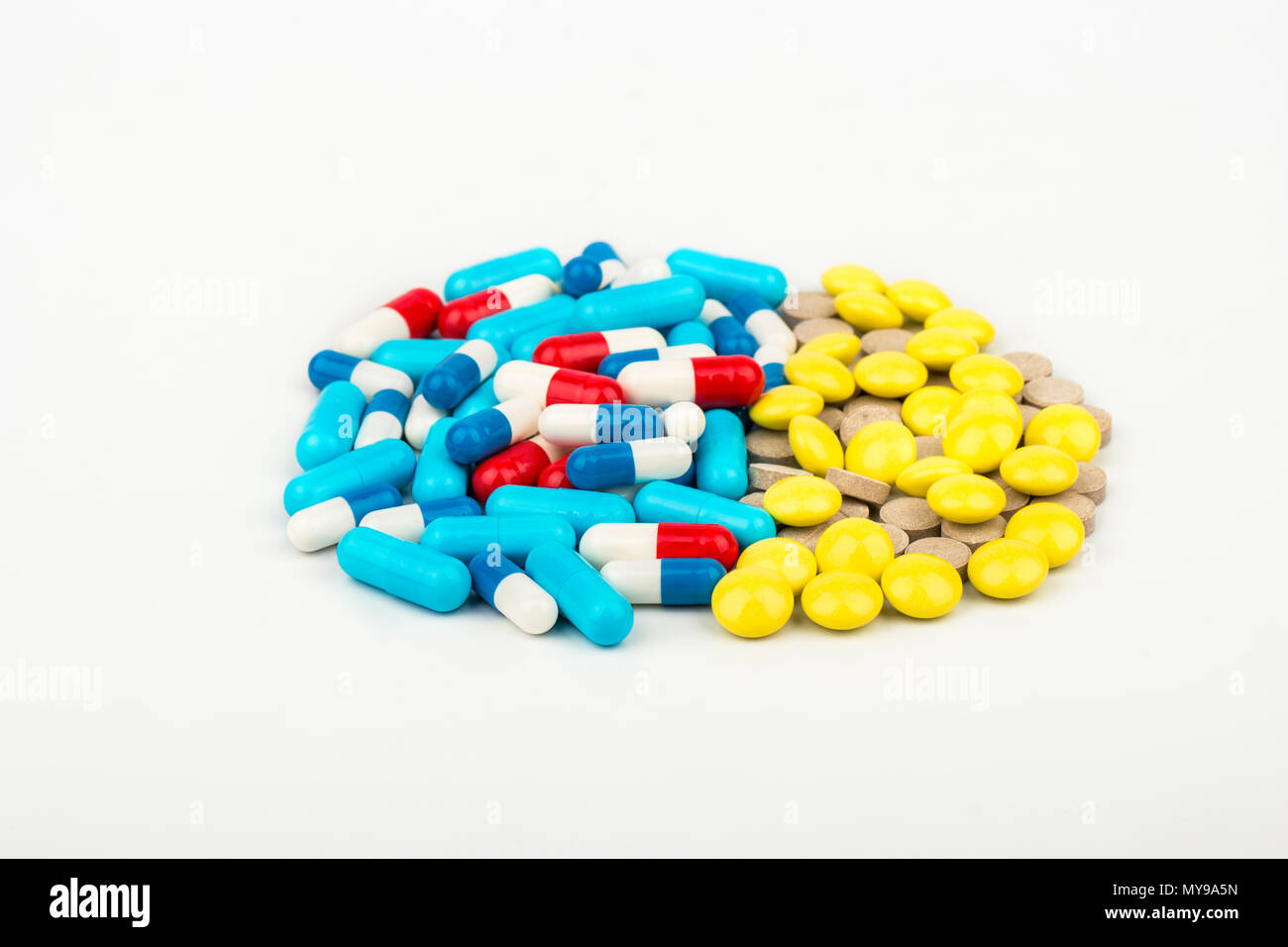 Pile of multi-colored capsules and tablets on a white background Stock ...