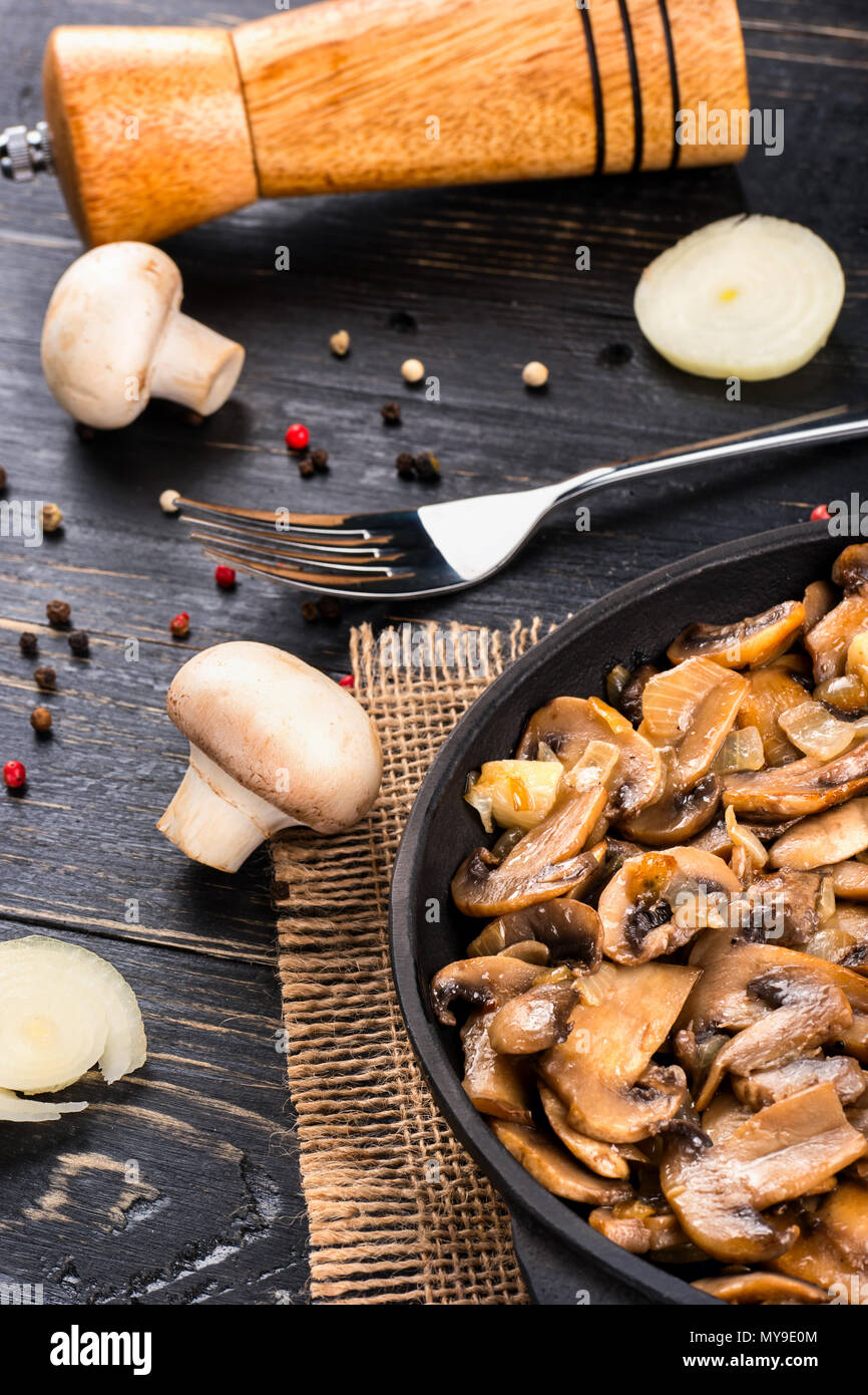 The fragrant fried champignons with ingredients and spices on a dark ...