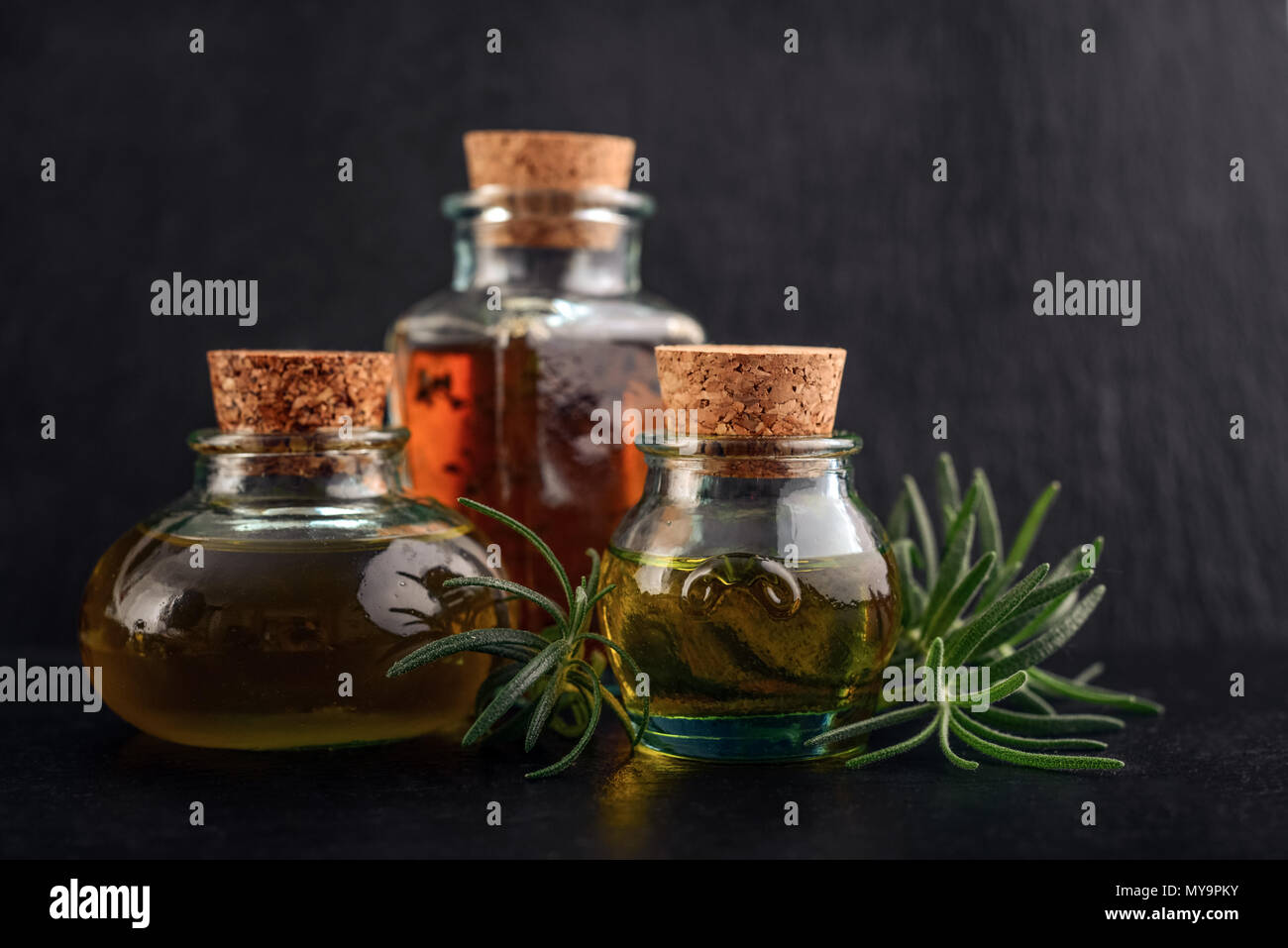Different essential oils in vintage bottles with cork on black ...