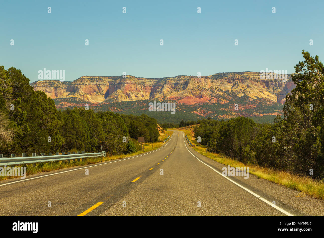 A highway runs along the red-sandstone. Empty road in Arizona, USA ...
