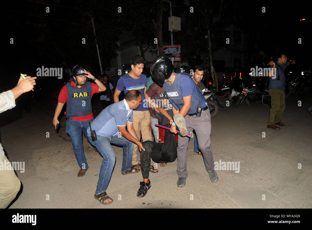 Dhaka, Bangladesh - July 01, 2016: Police carry an injured man near the ...