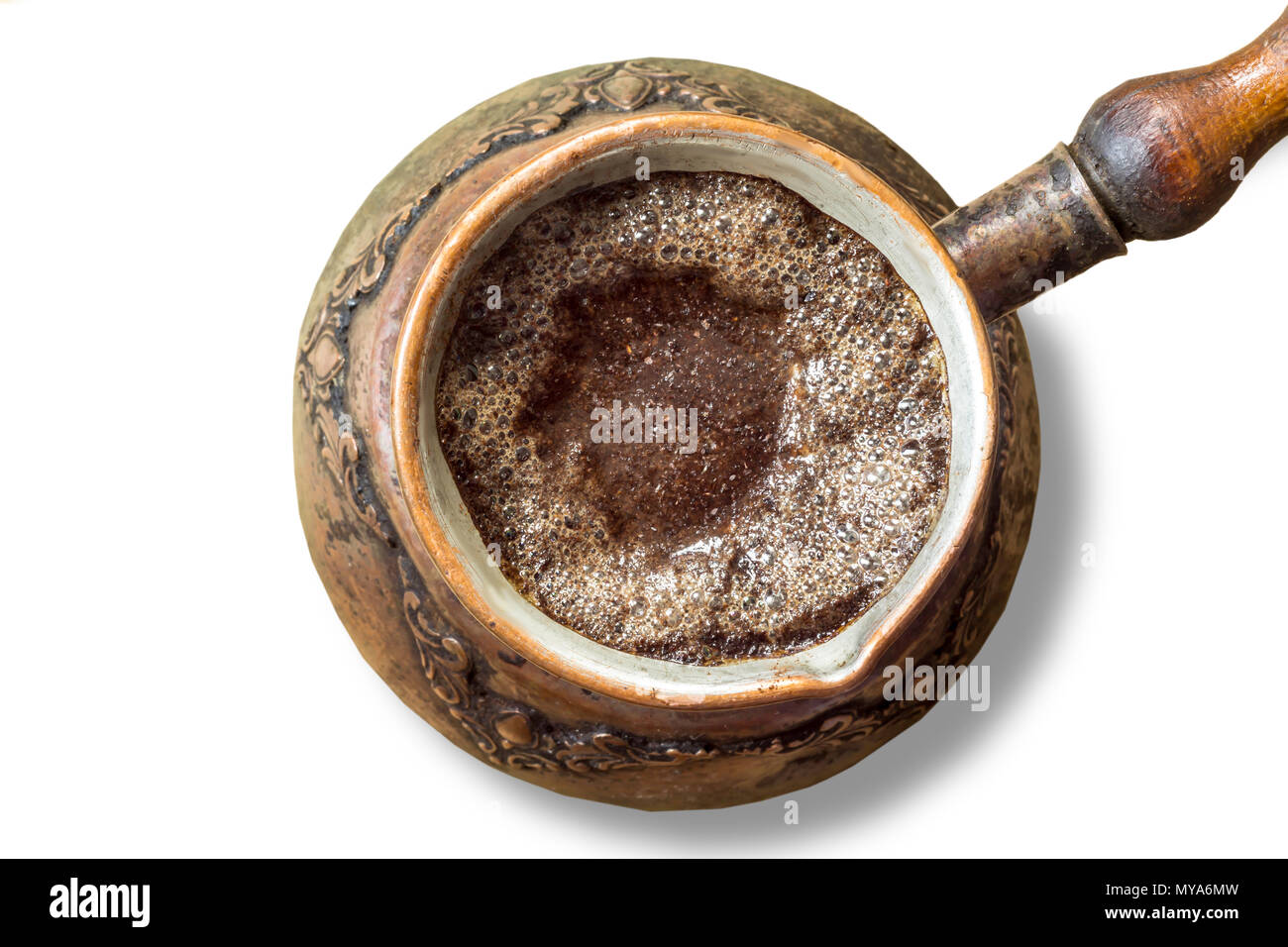 An old coffee maker made in the Middle East. Coffee foam on the surface ...