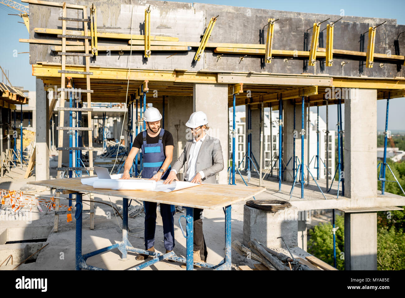 Engineer with worker at the construction site Stock Photo - Alamy