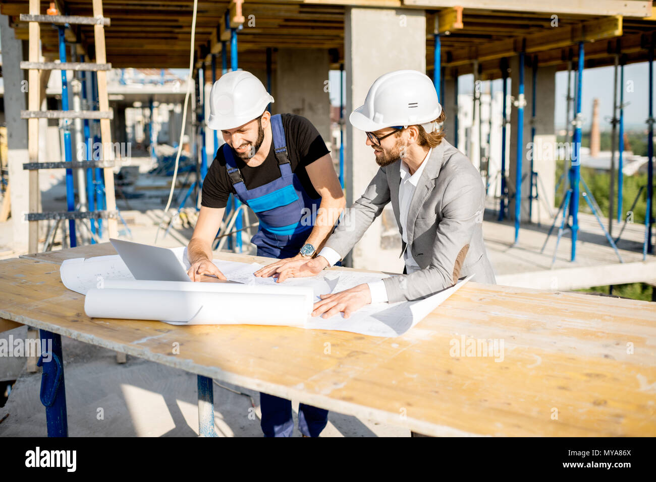 Engineer with worker at the construction site Stock Photo - Alamy