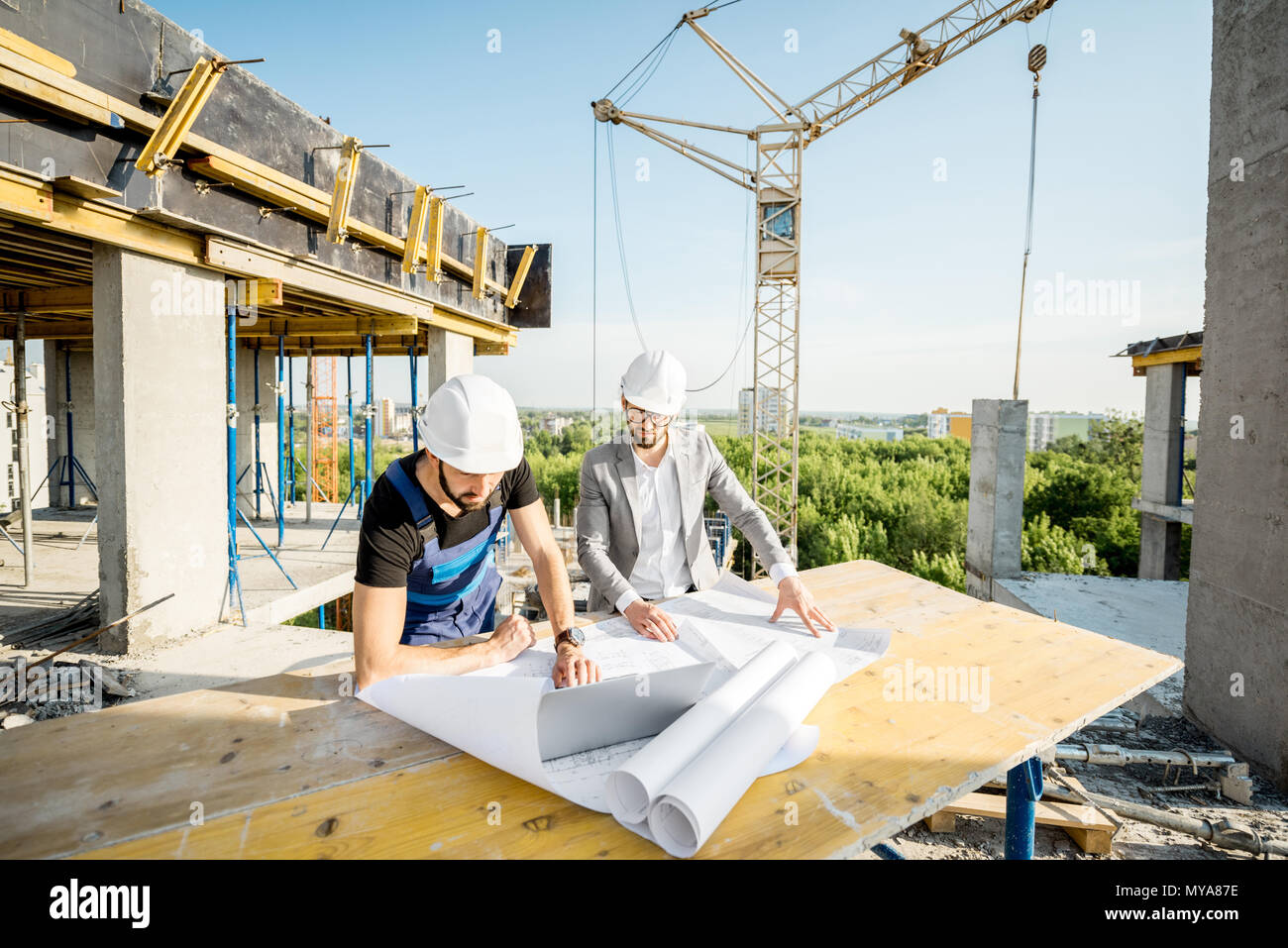 Engineer with worker at the construction site Stock Photo - Alamy