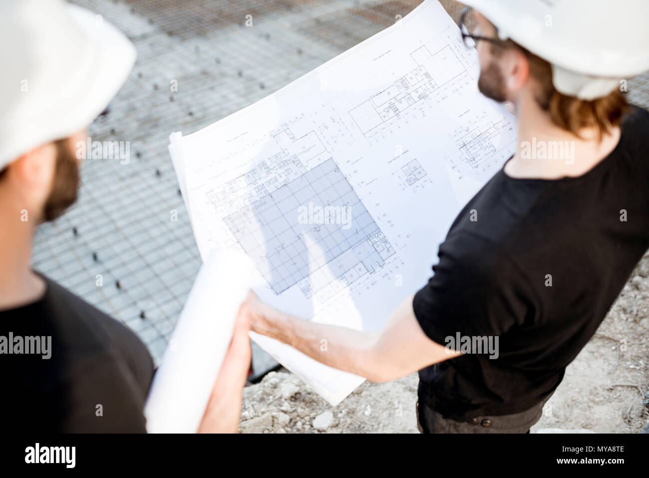 Builders working with architectural drawings Stock Photo - Alamy