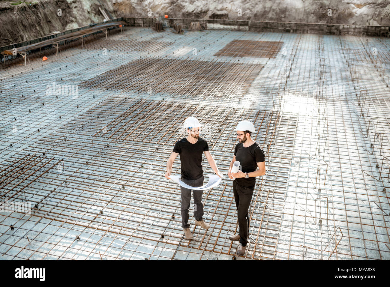 Builders with drawings at the construction site Stock Photo - Alamy