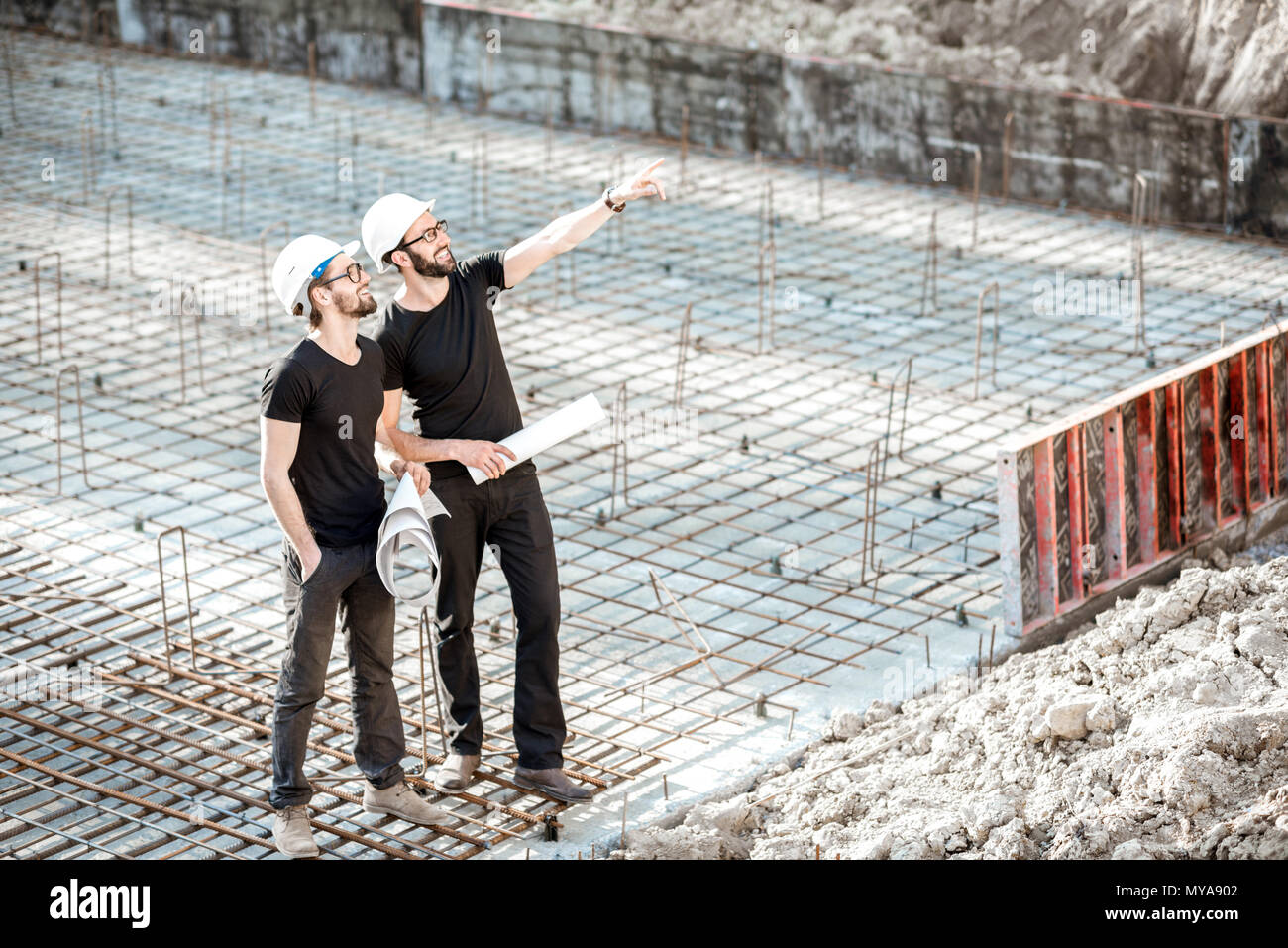 Builders with drawings at the construction site Stock Photo - Alamy