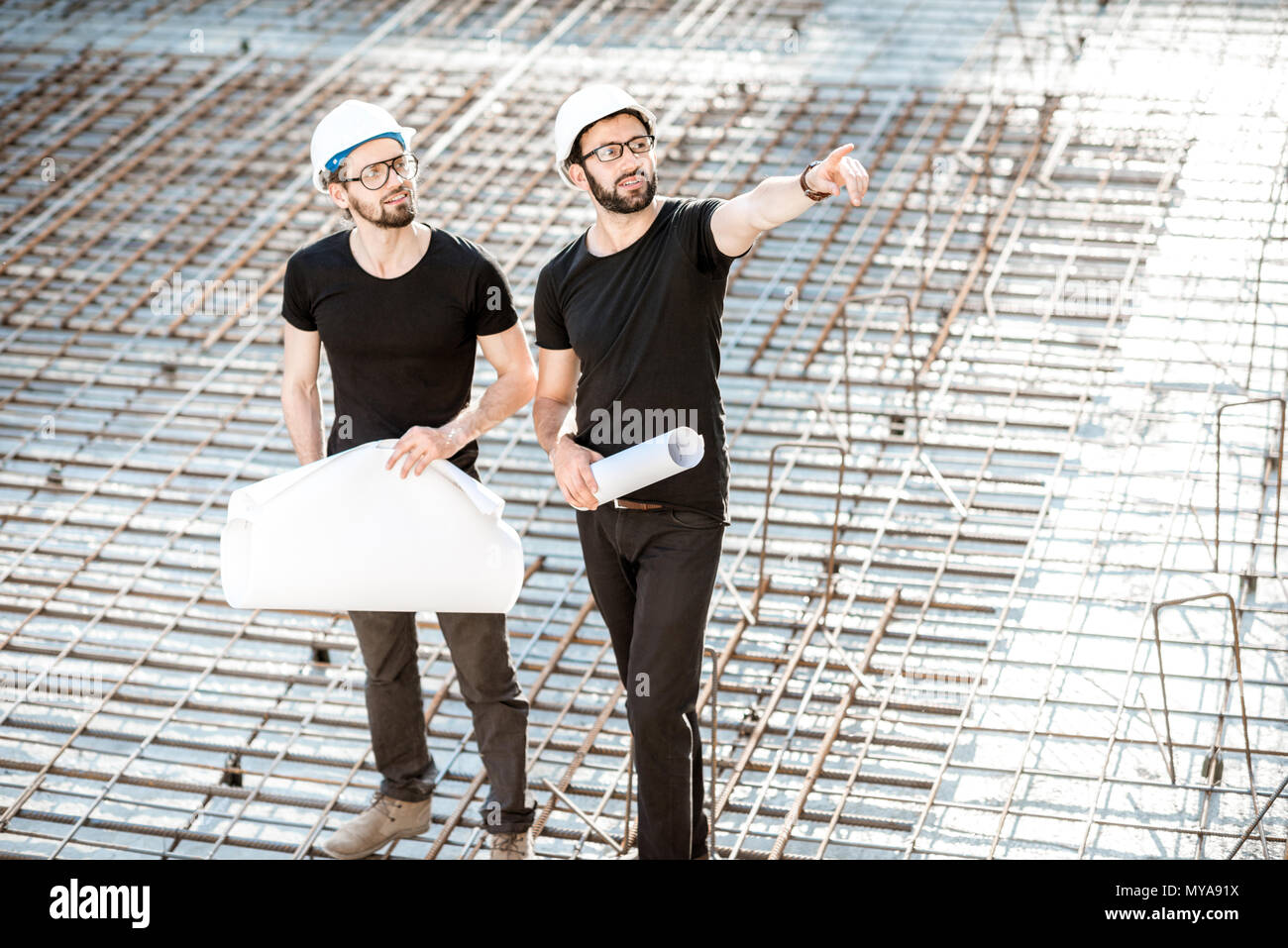 Builders with drawings at the construction site Stock Photo - Alamy