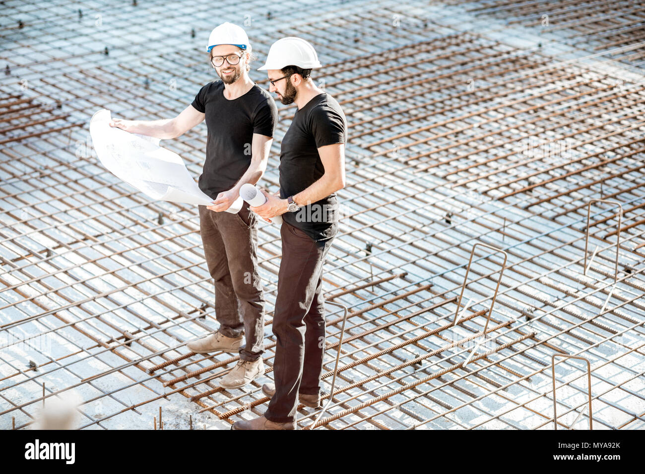 Builders with drawings at the construction site Stock Photo - Alamy