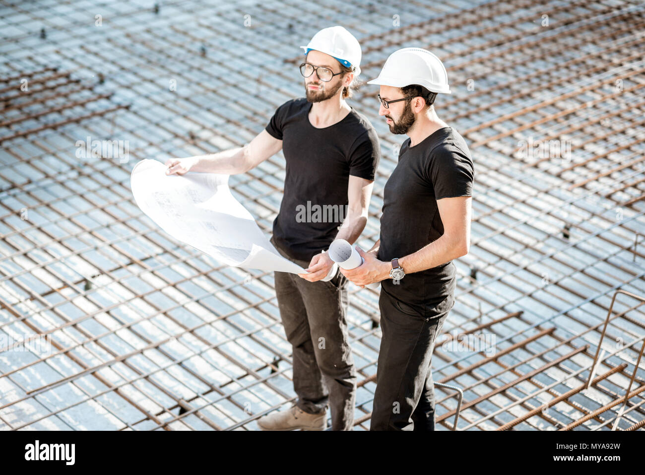 Builders with drawings at the construction site Stock Photo - Alamy