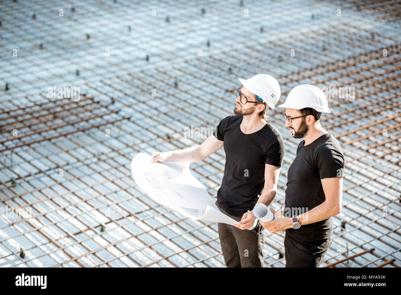 Builders with drawings at the construction site Stock Photo - Alamy