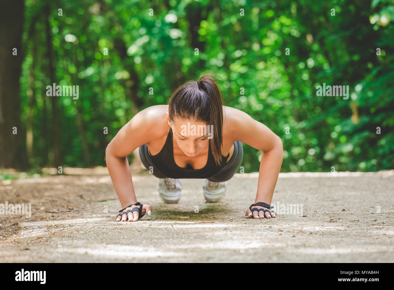 Sportswoman doing push ups in nature Stock Photo - Alamy