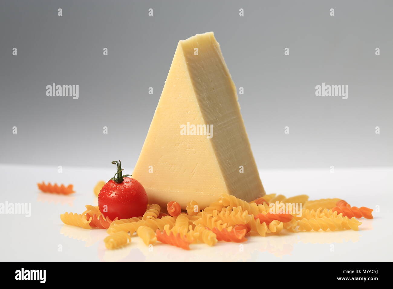 Block and triangle sliced cheese with a slice of tomato Stock Photo - Alamy