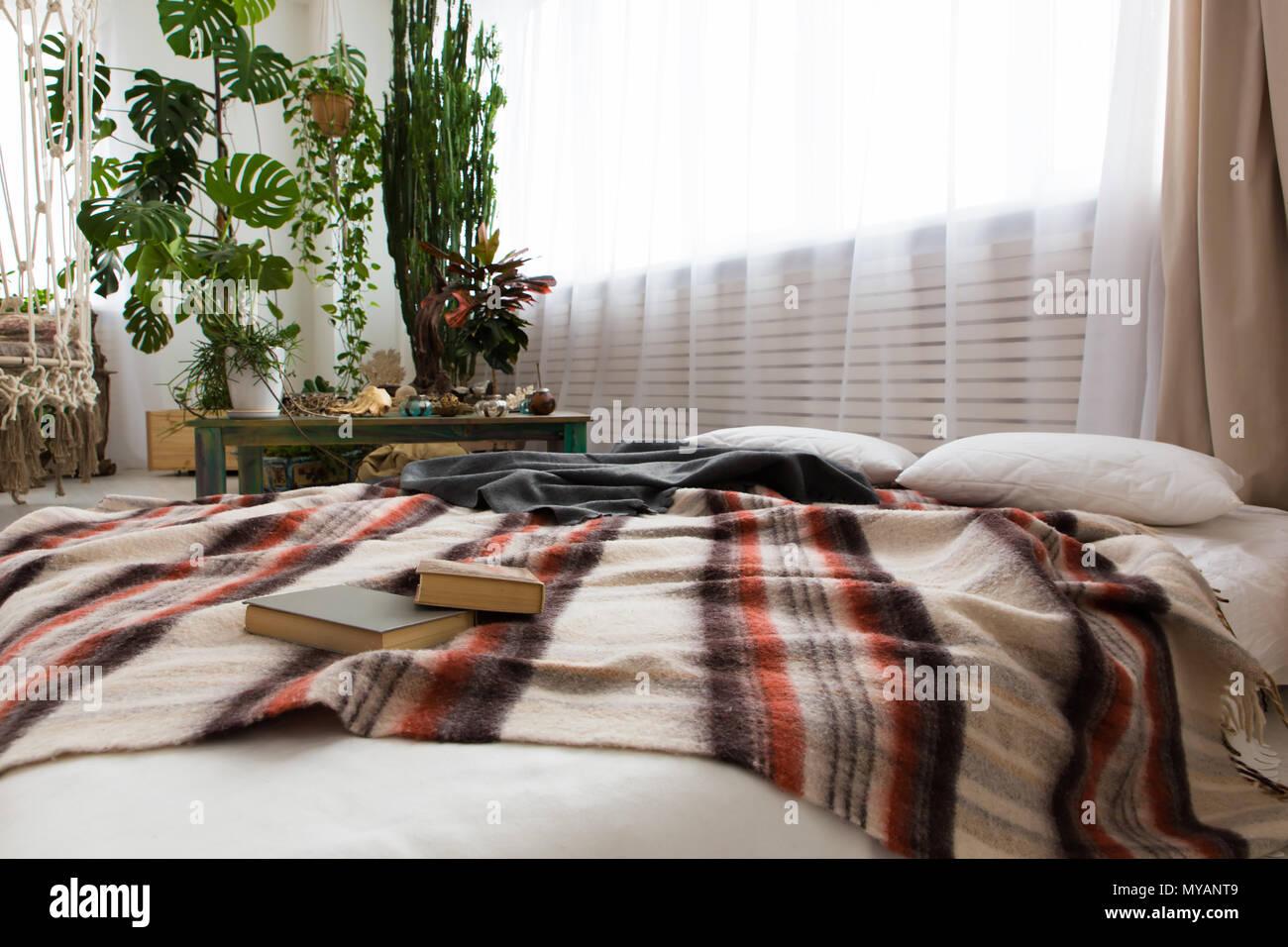 interior of a modern studio apartment with lots of plants and a bed on ...