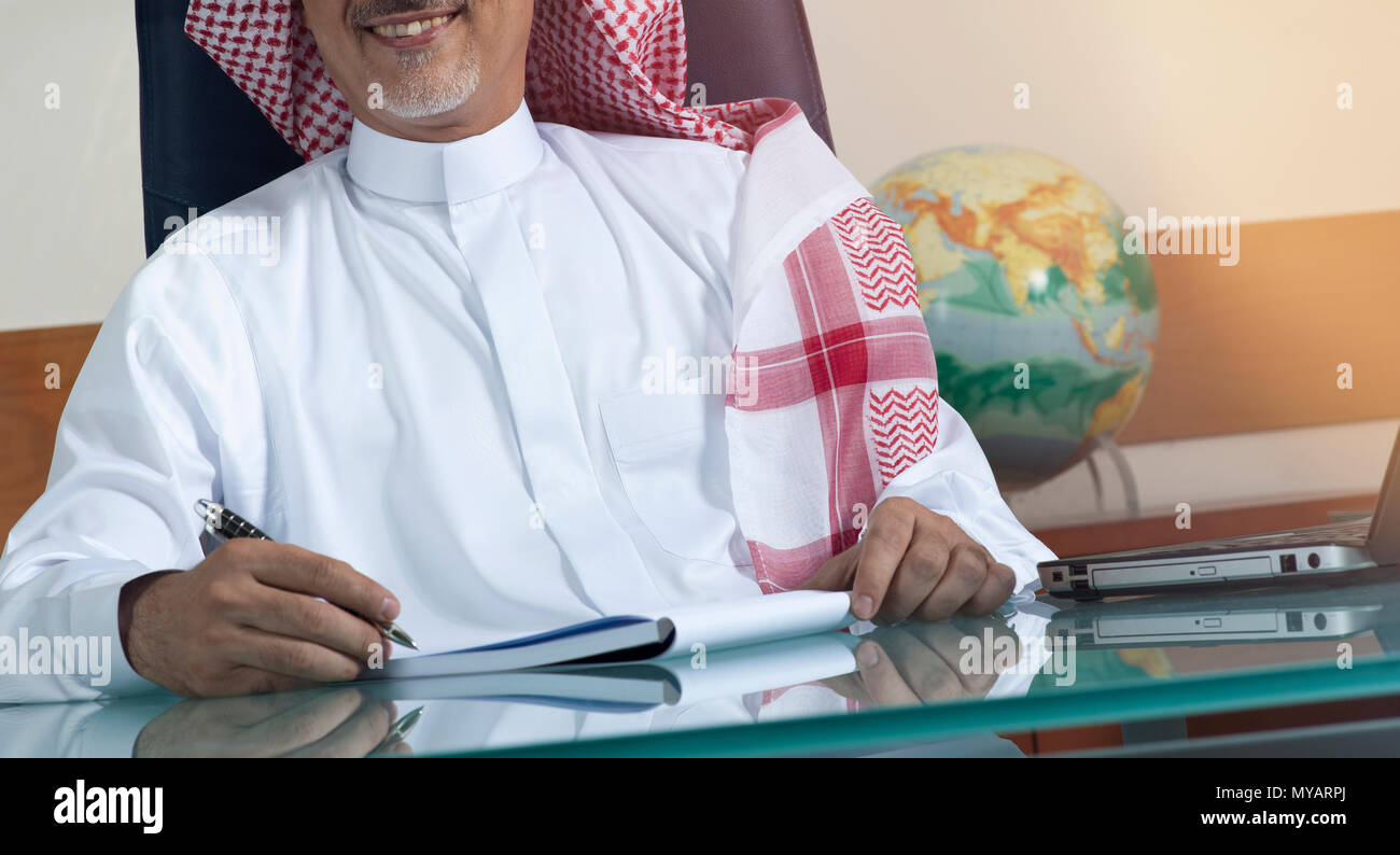 Senior Saudi Businessman Hand Writing At His Desk with Laptop Stock ...