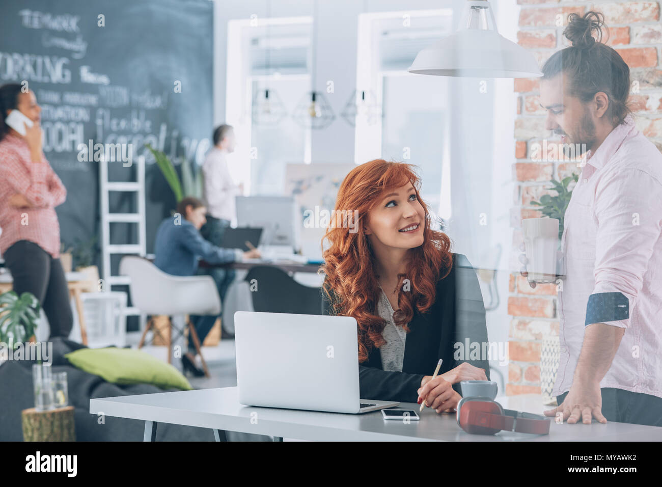 Young woman flirting with coworker during work Stock Photo - Alamy