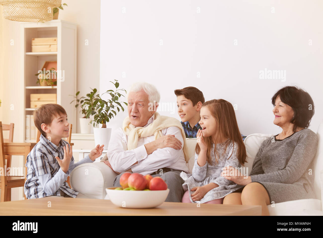 Happy children spending time with grandparents in living room Stock ...