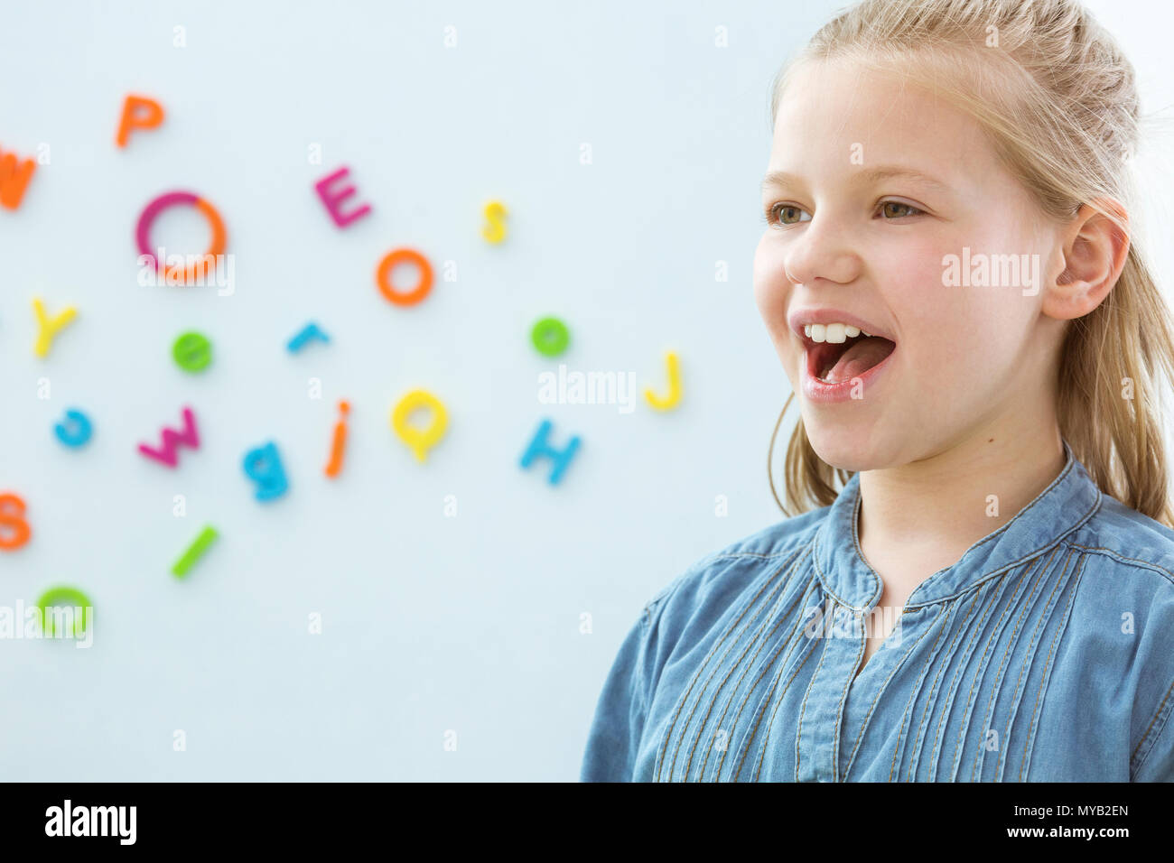 Copy space with little girl opening mouth in speech therapy office ...