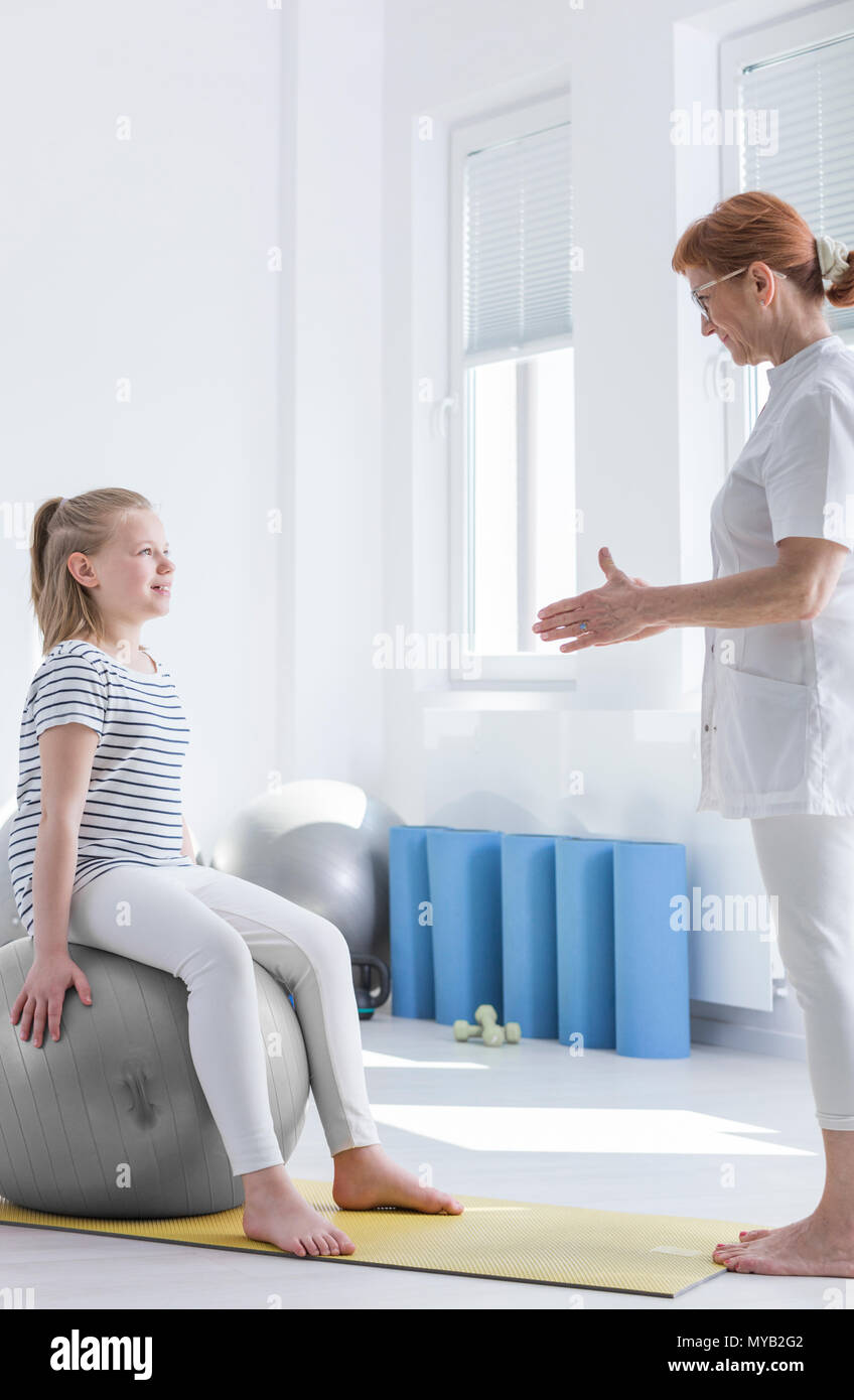 Child talking with friendly physiotherapist during rehabilitation ...
