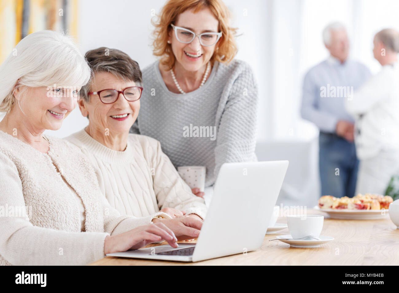 Three modern happy grandmothers using new technology laptop Stock Photo ...
