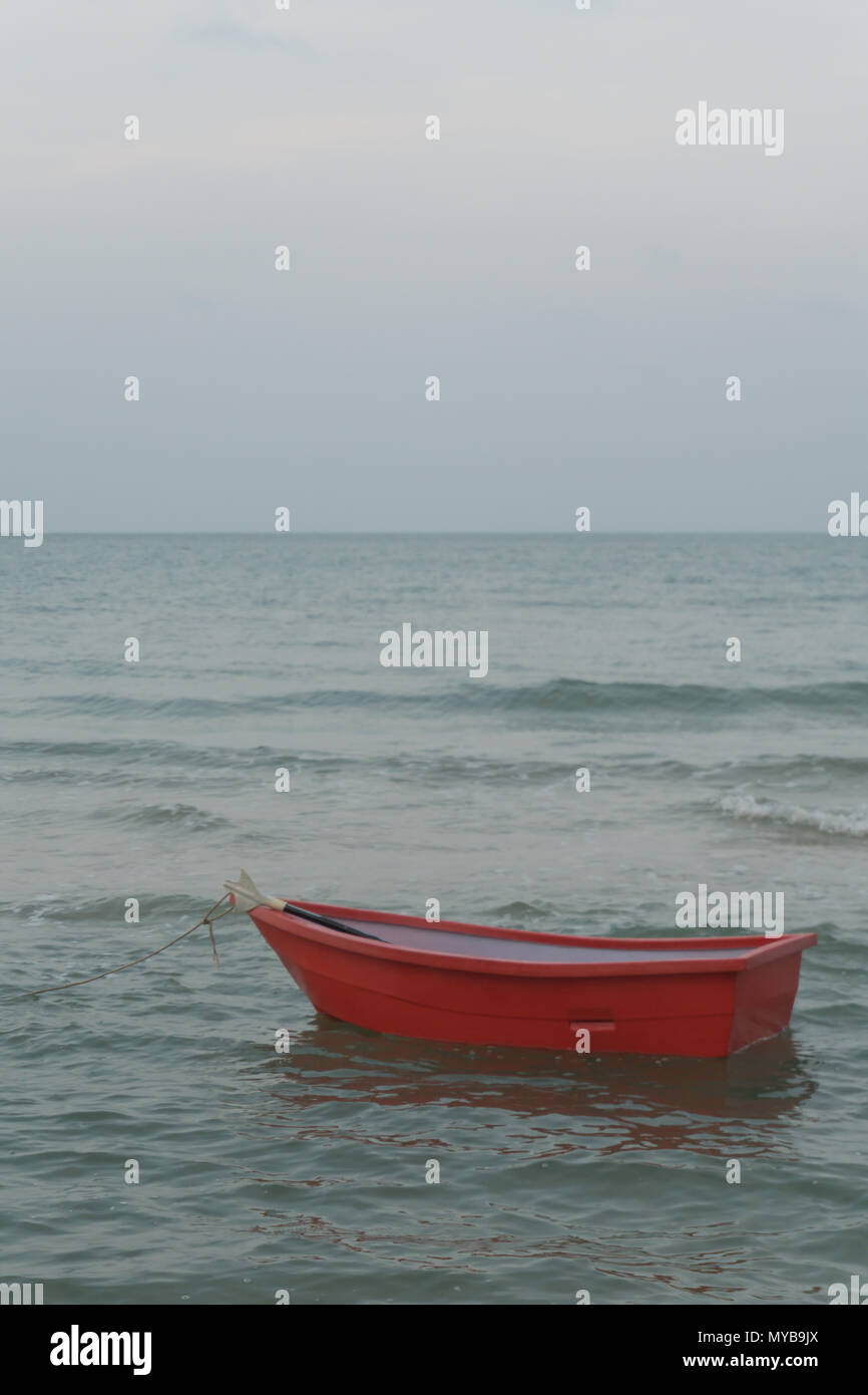 Red boat is floating in the sea Stock Photo - Alamy
