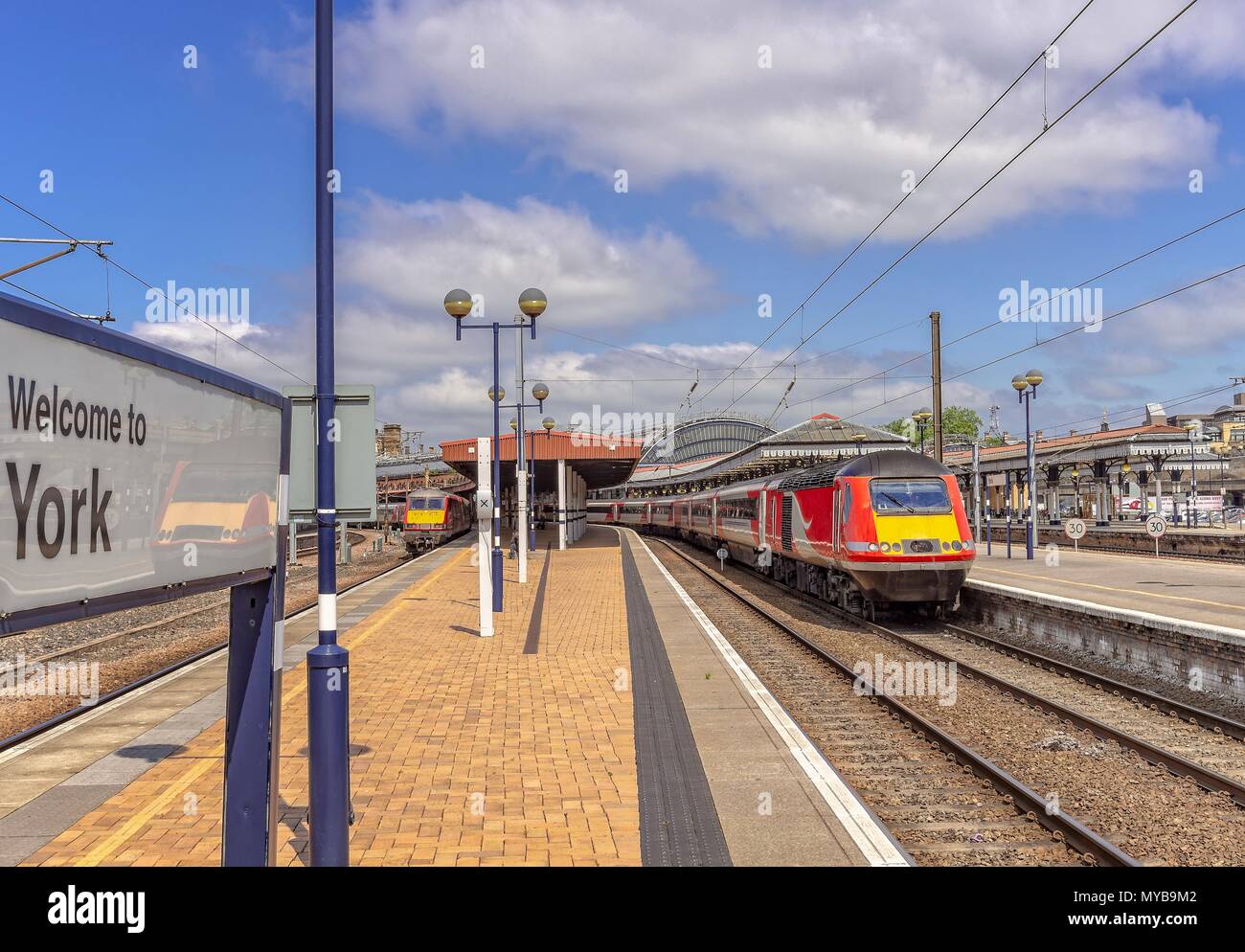 A train waits to depart at York Railway Station. A blue sky is overhead ...