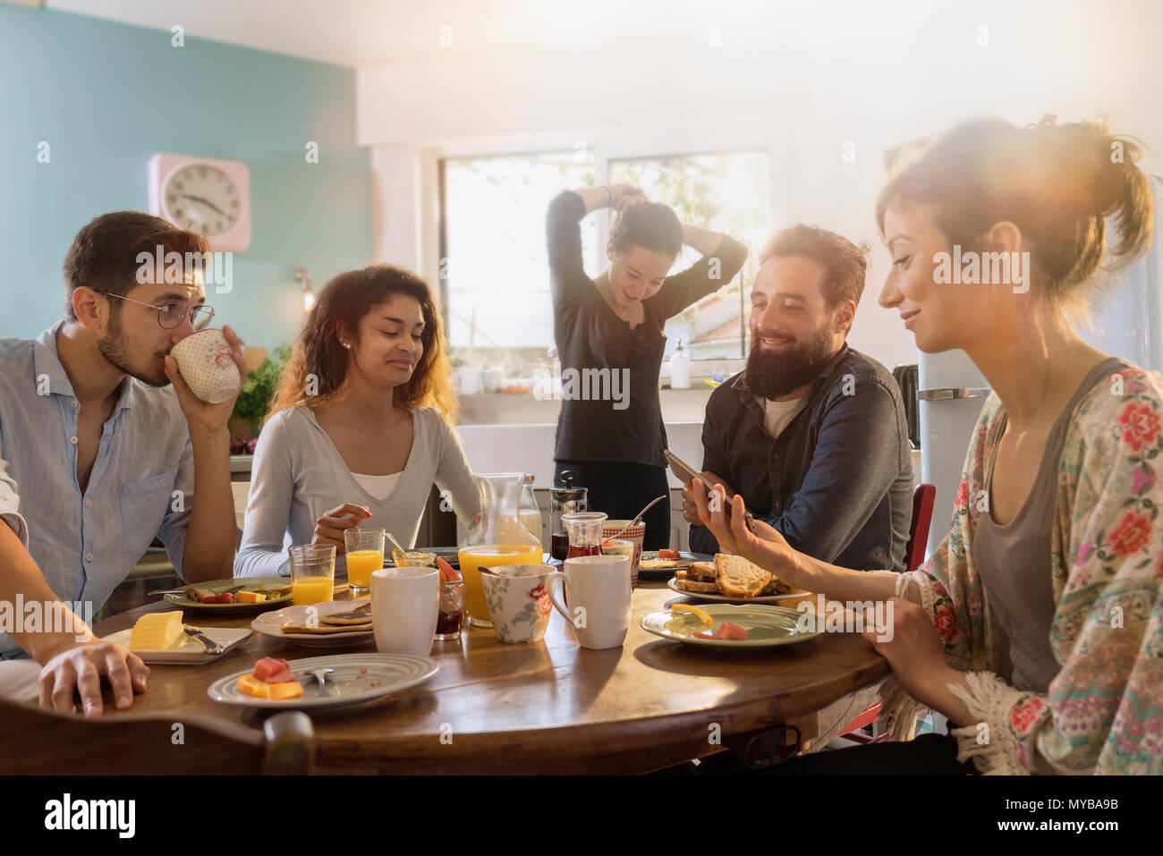 Friends sitting around table sharing hi-res stock photography and ...