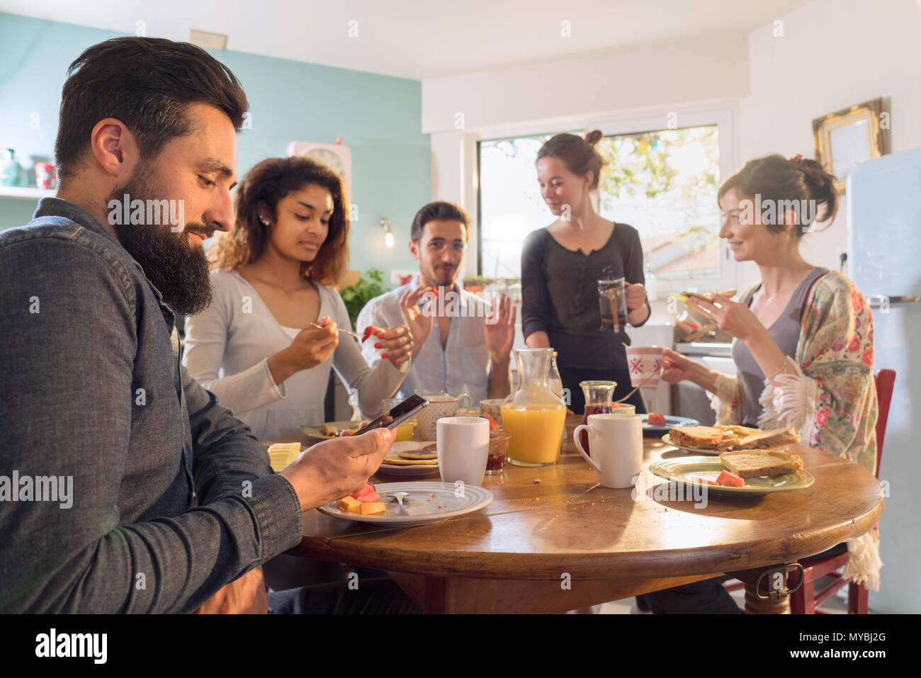 Group friends gathered around table hi-res stock photography and images ...