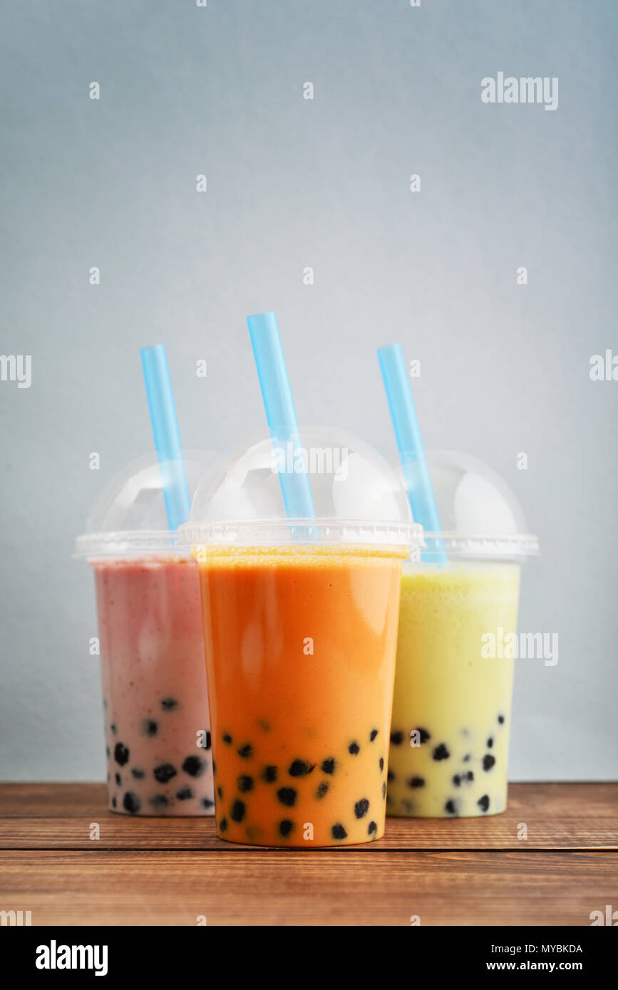 Various Bubble Tea in a plastic cups with drink straws on blue ...