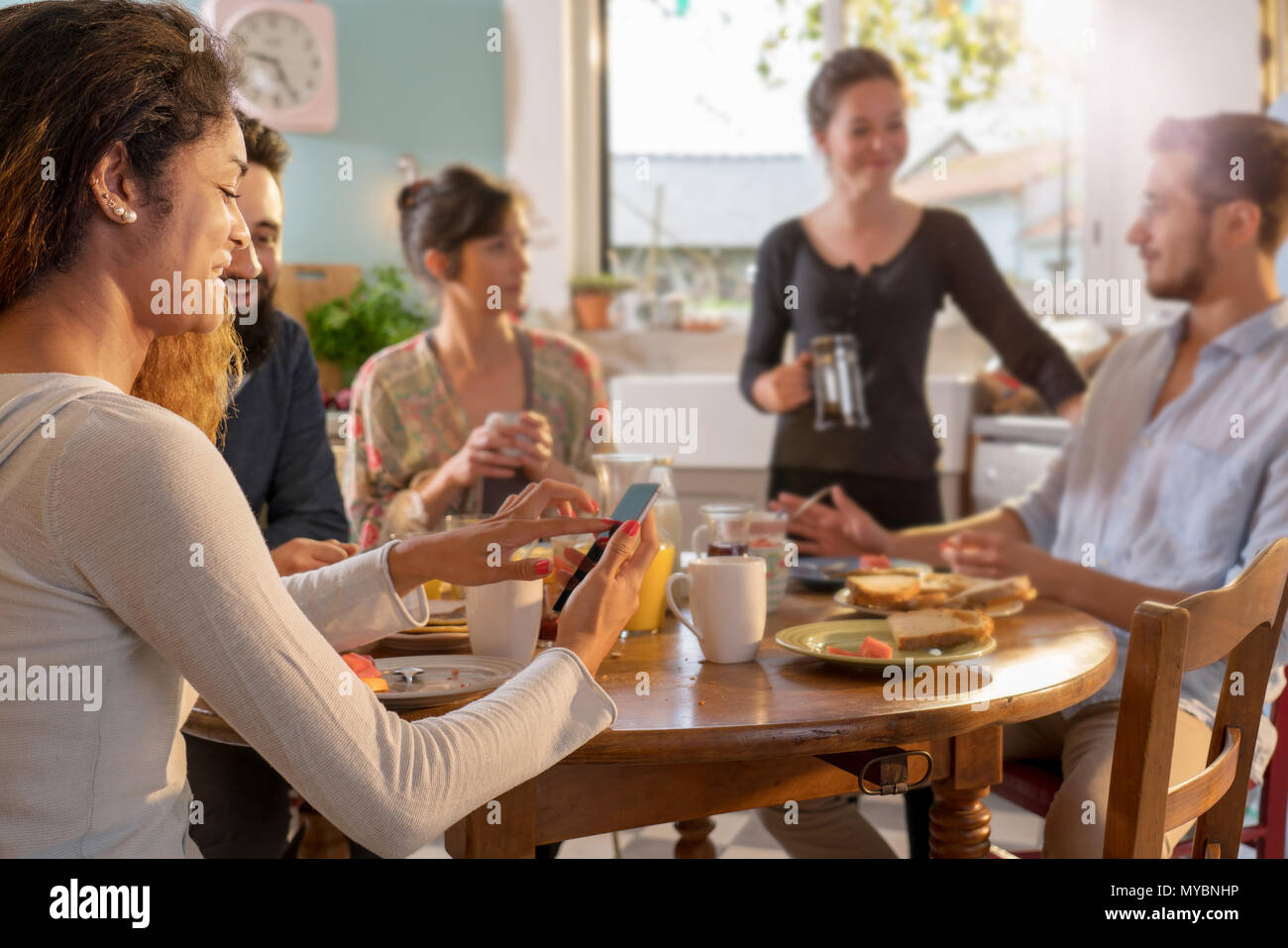Friends sitting around table sharing hi-res stock photography and ...