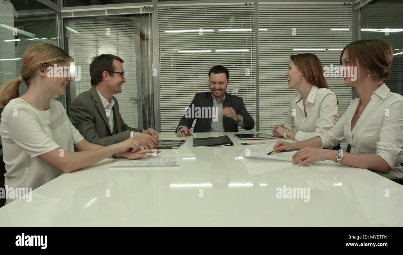 Casual business team laughing during meeting in the office Stock Photo ...