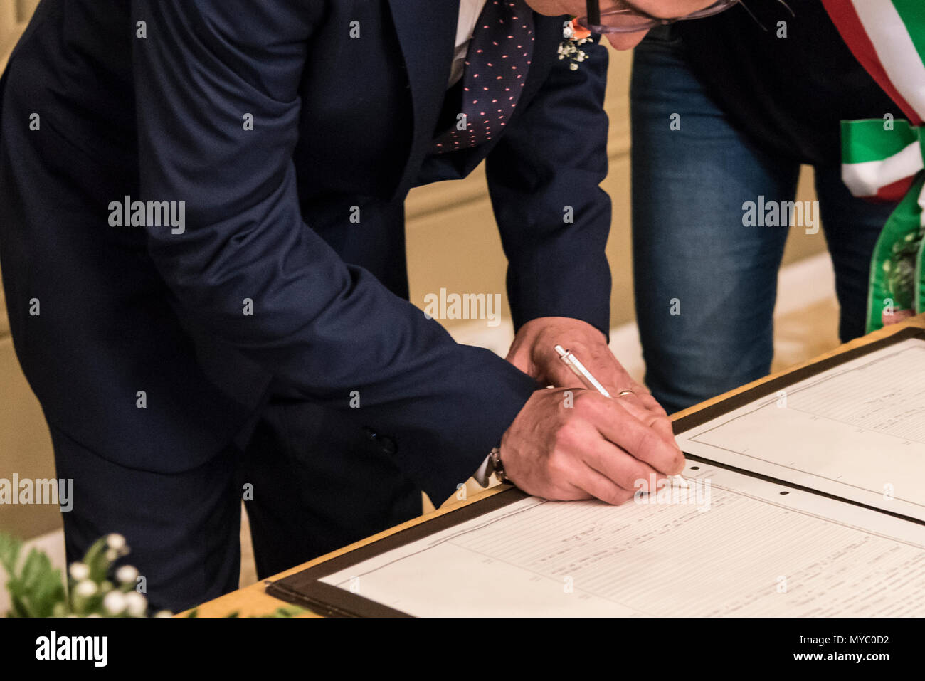 Male wedding witness signs the register during communal ceremony Stock ...