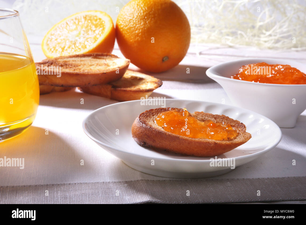 Morning Breakfast set with orange jam on bread toast and juice in glass ...
