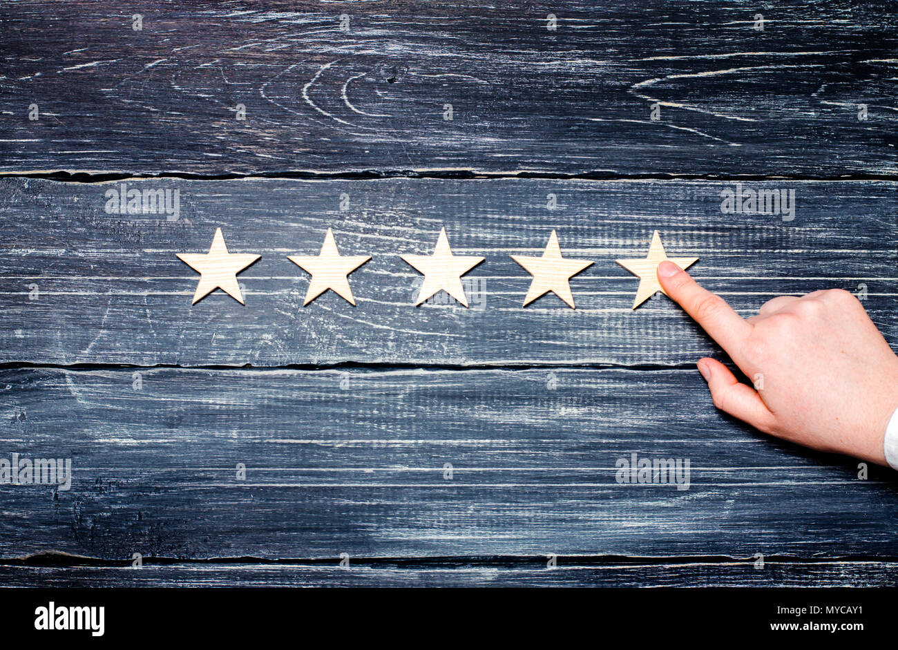 A woman's hand points to the fifth star. Quality status is five stars ...