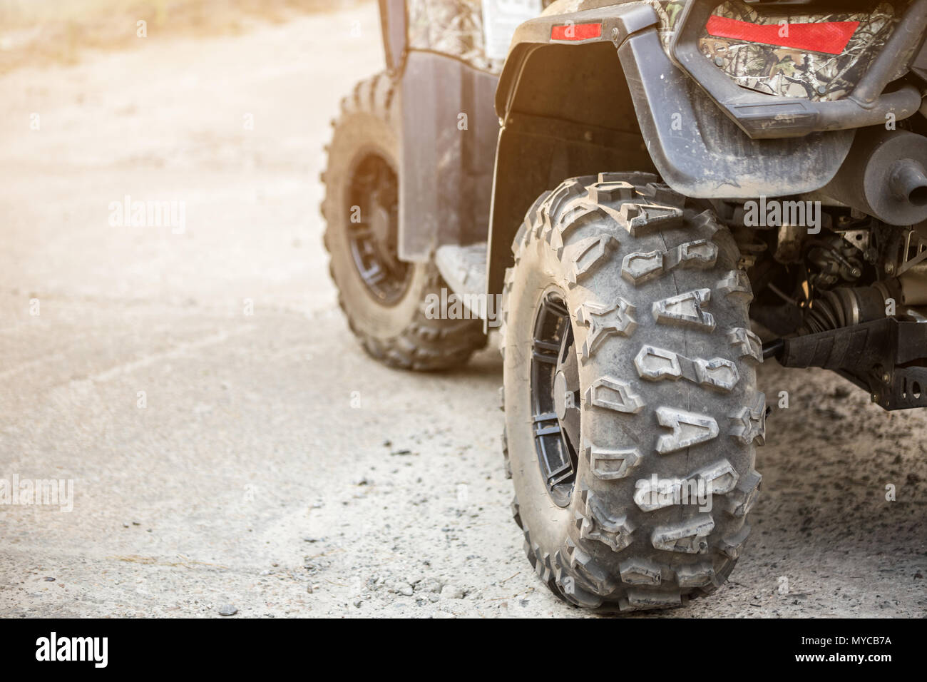 Close-up tail view of ATV quad bike. Dirty wheel of AWD all-terrain ...