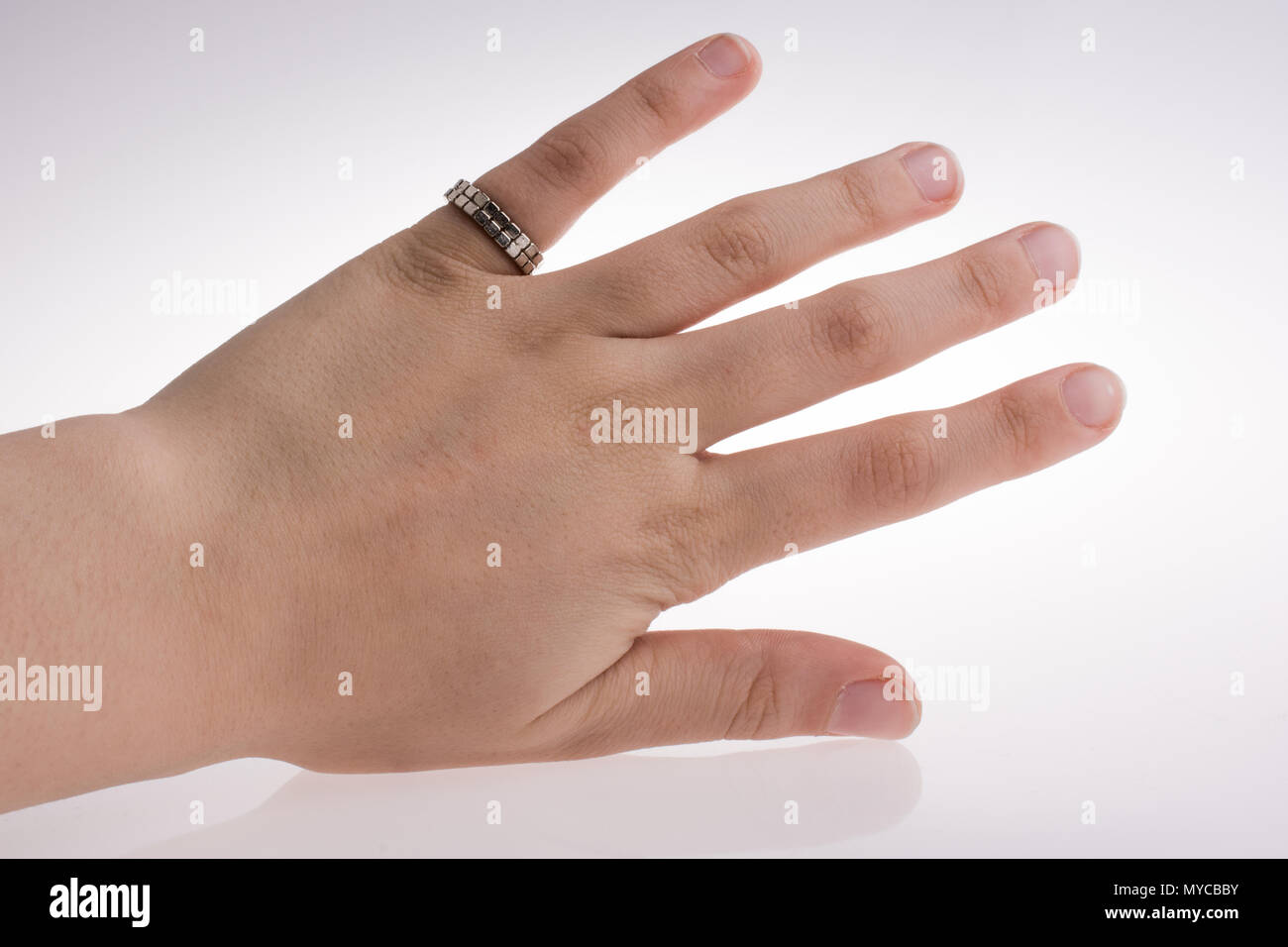 Hand wearing a ring on a white background Stock Photo - Alamy