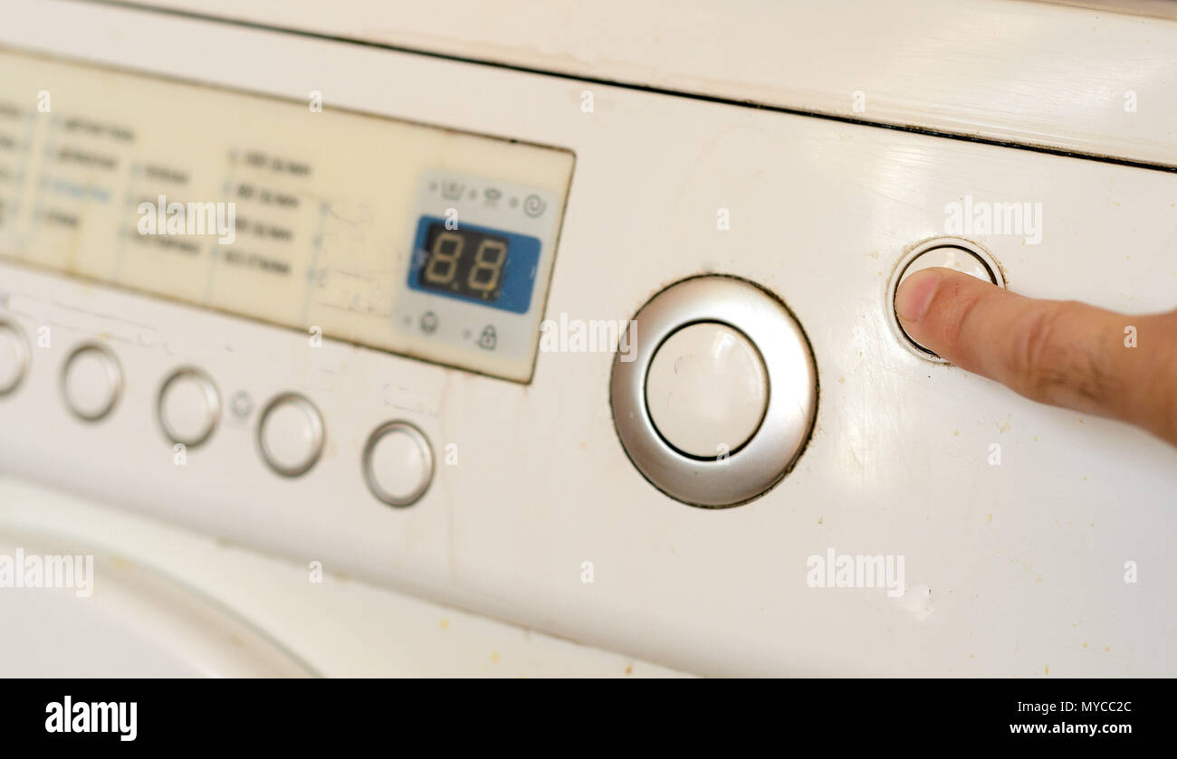 Push button switch on washing machine.Copyspace left Stock Photo - Alamy