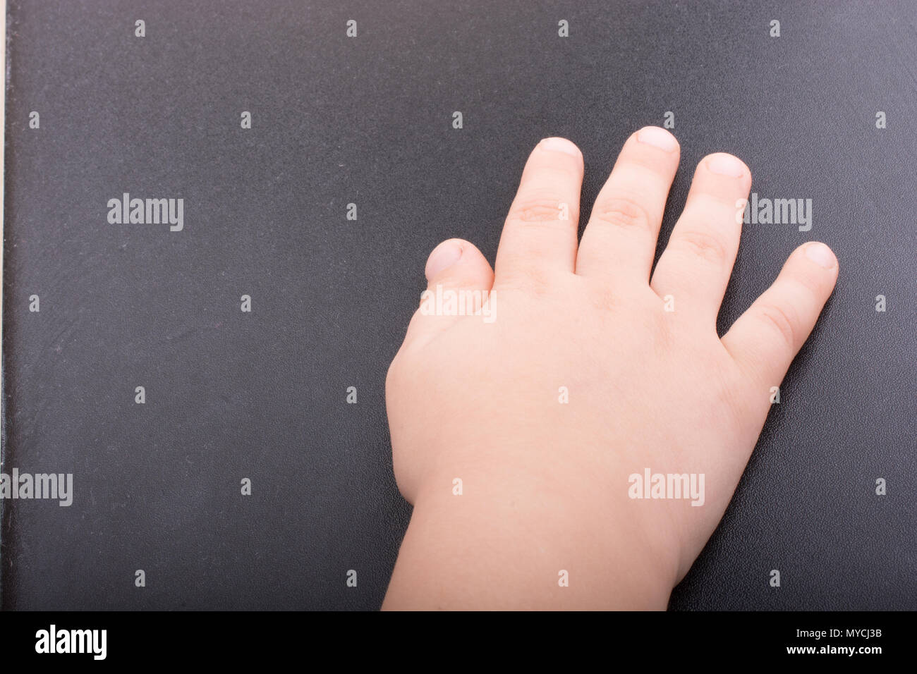 Toddler hand with dark color background Stock Photo - Alamy