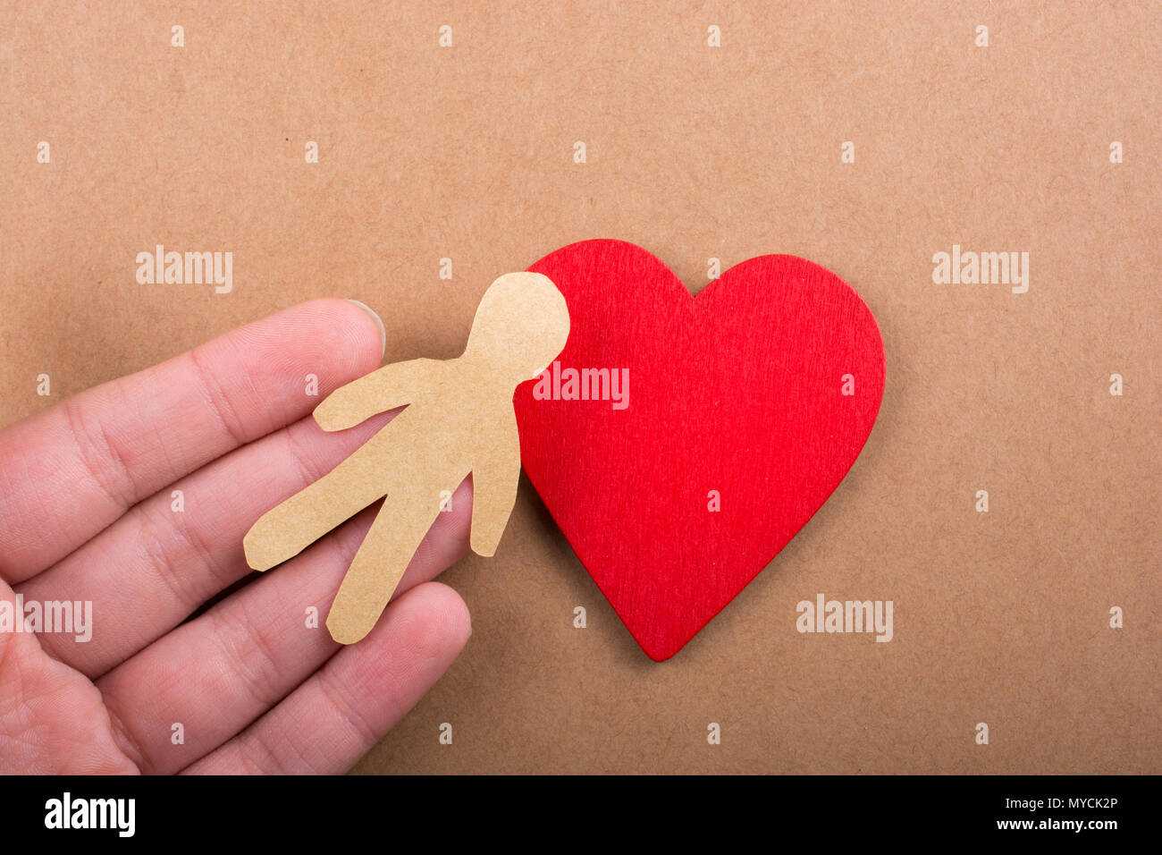 Paper Man in hand beside heart shape in view Stock Photo - Alamy