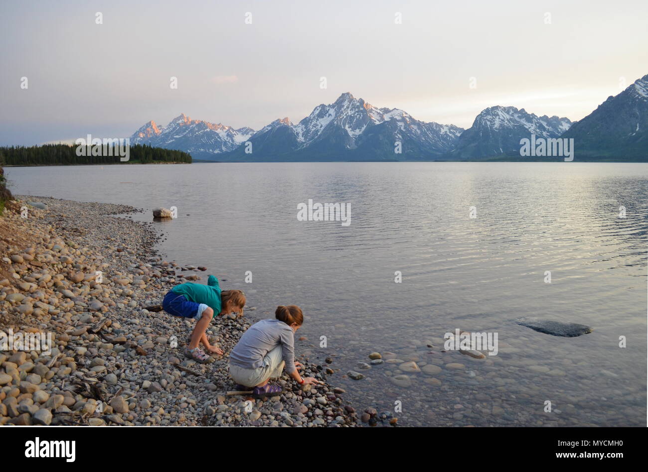Two girls playing on the lake shore in Grand Teton National Park at ...