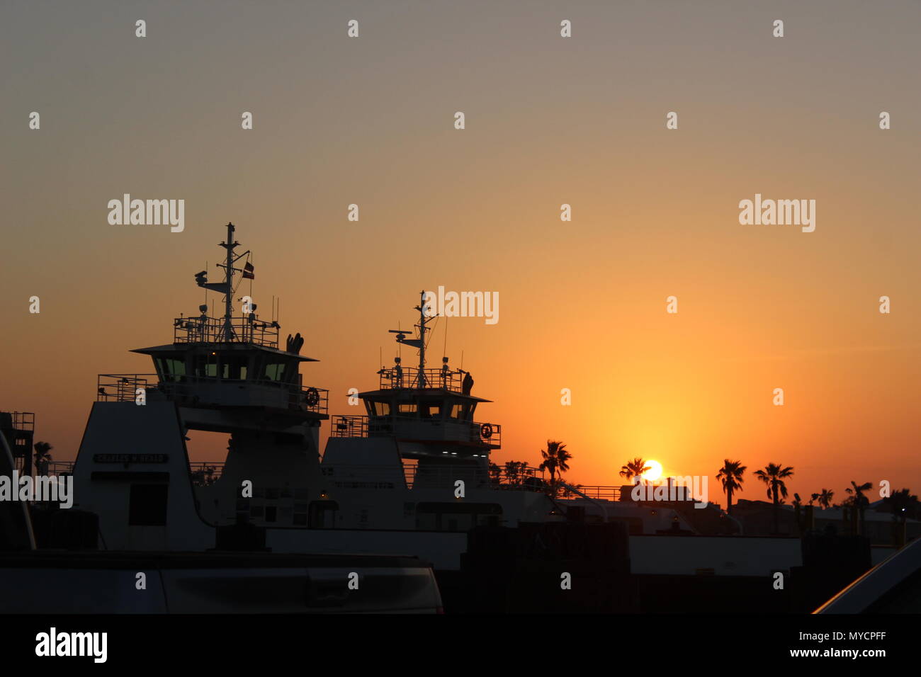 The sun sets on several ships in a Texas waters Stock Photo - Alamy