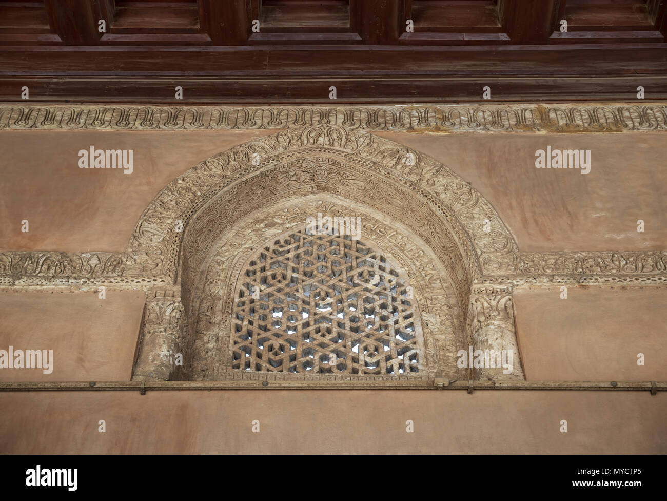 Perforated arched stucco window decorated with geometrical patterns and ...